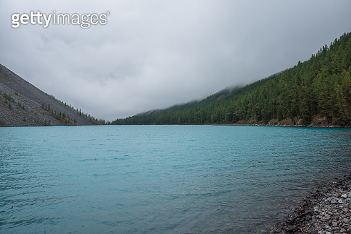 Dramatic meditate landscape with ripples on big azure mountain lake ...