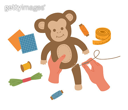 Soft toy sewing process. Hands holding a needle and thread and handmade ...