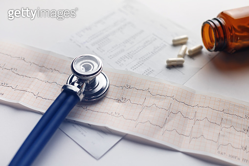 Stethoscope on cardiogram and blood tests with medicines in jar ...