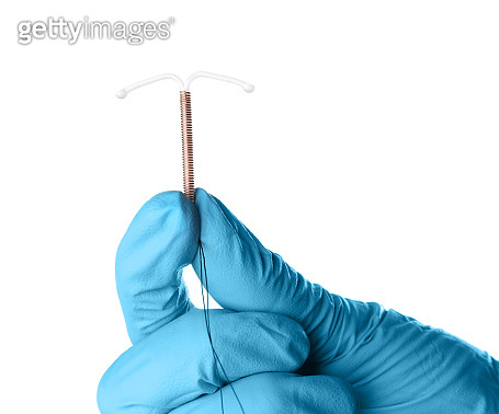 Gynecologist holding copper intrauterine contraceptive device on white ...