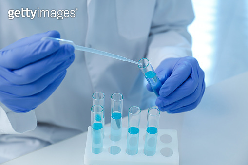Scientist dripping sample into test tube in laboratory, closeup ...