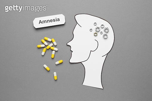 Word Amnesia, pills and human head cutout with metal nuts as brain on ...