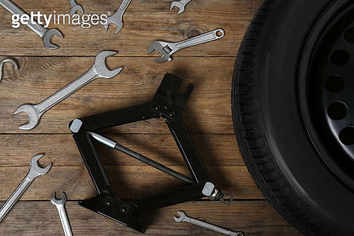 Car wheel, scissor jack and wrench set on wooden surface, flat lay 이미지 ...