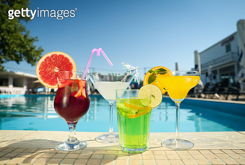 Tasty refreshing cocktails on edge of swimming pool. Party drinks ...