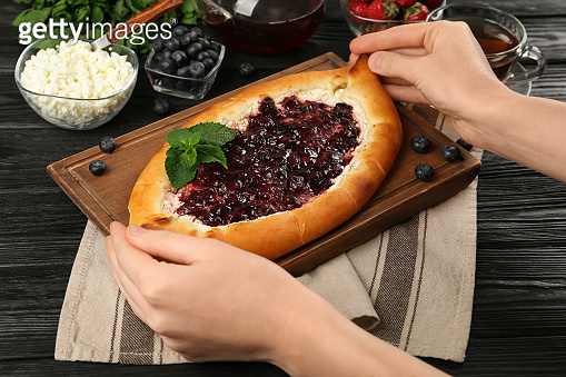 Woman eating delicious sweet cottage cheese pastry with cherry jam at ...