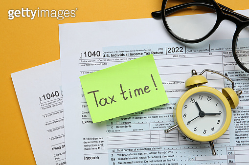 Reminder note with words Tax Time, documents, glasses and alarm clock ...