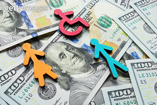 Money and figures on them as a symbol of income inequality and wage gap ...