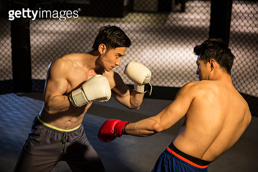 Young male boxer in a boxing match in a boxing pool, attacking and ...