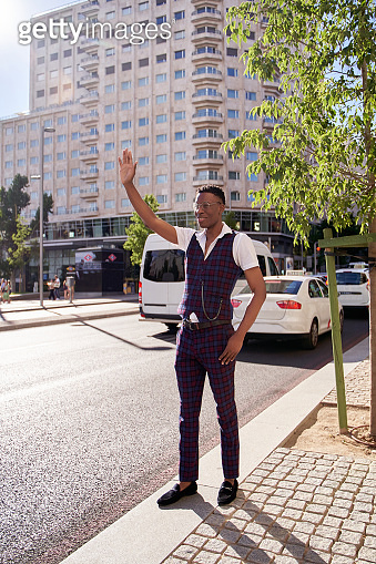 Man hailing a taxi. man raising his hand to signal for a taxi in the ...