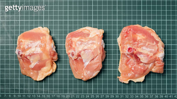 Raw chicken thigh with skin, boneless, for cooking on wooden cutting ...