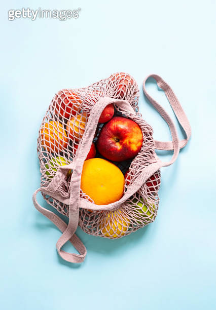 String mesh bag for grocery with various fruits. Reusable shopping tote ...