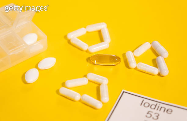 Multiple anti-radiation pills based on iodine on a yellow background in ...