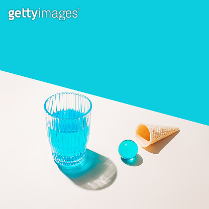 Transparent blue cocktail with waffle ice cream cone and blue glass ...