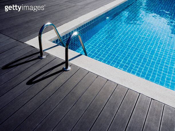 Stone edge frame on the square swimming pool with clean clear water ...