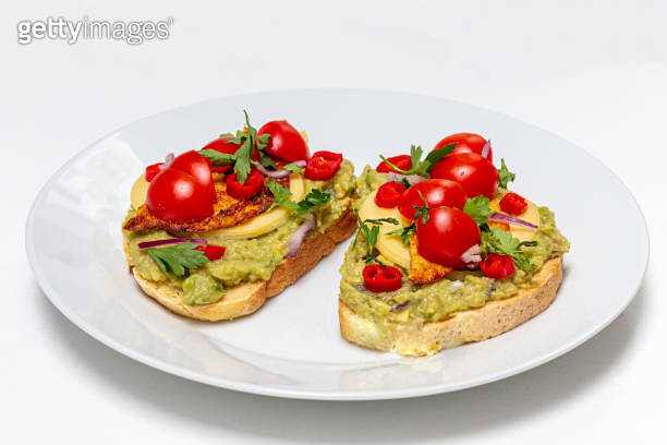 Delicious open vegan sandwich with guacamole, zucchini, tomato, cheese ...
