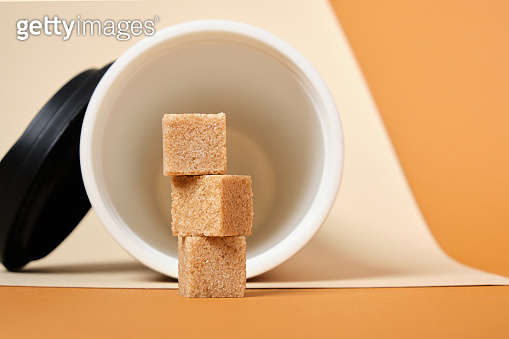 brown sugar cubes and thermo mug made of cork on a beige and brown ...