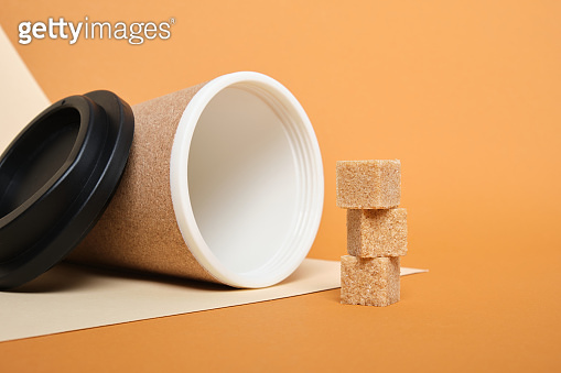brown sugar cubes and thermo mug made of cork on a beige and brown ...