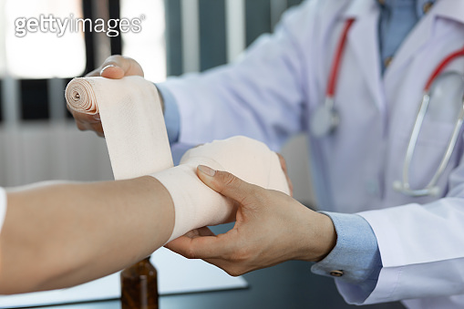 First aid concepts and wrist injury treatment. Doctor wrapped around ...