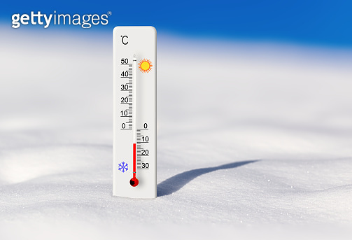 White celsius scale thermometer in the snow. Ambient temperature minus ...
