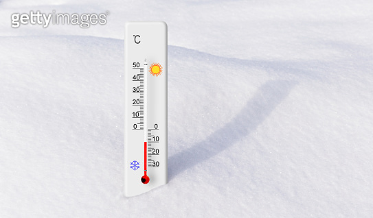 White celsius scale thermometer in the snow. Ambient temperature minus ...