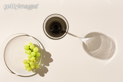 Sparkling wine in champagne glass gray colored glass and grape on beige ...