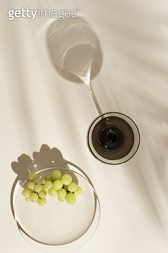 Sparkling wine in champagne glasses gray color glass and grape on beige ...