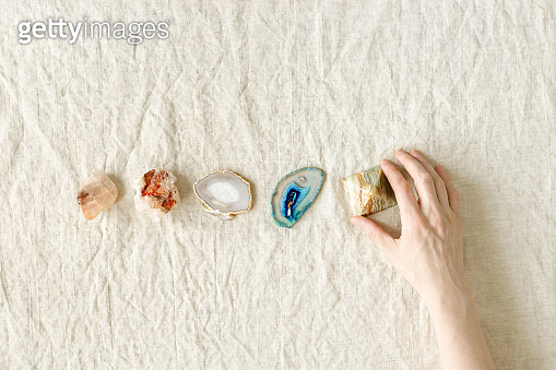 Row of crystals on table, woman hand holding onyx pyramid, healing ...