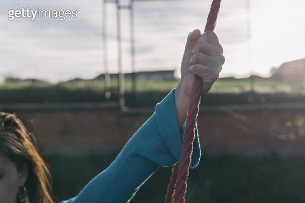 Woman's hand grabbing a rope from the swing thrown into the air. 이미지 ...
