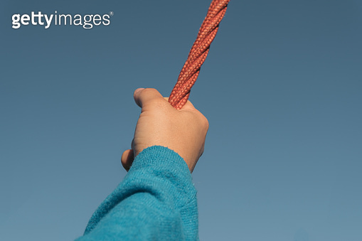 Woman's hand grabbing a rope from the swing thrown into the air ...