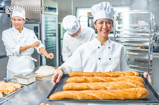Smiling young female bakers looking at camera.Chef baker in a chef ...