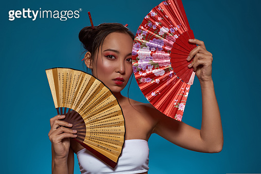 Asian girl posing with traditional handheld fans 이미지 (1414602528) - 게티이미지뱅크