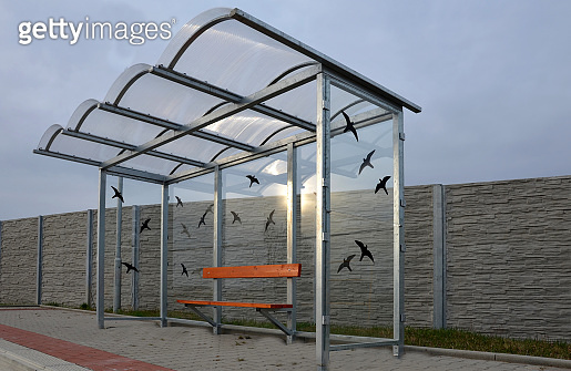 city bus stop. glass shed with integrated wooden bench. only the roof ...