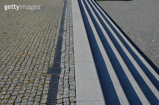 wide granite stone staircase looks representative. cobblestone tiles ...