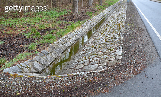 Sewer pipes under the bridge. crossing the ditch by the road. concrete ...