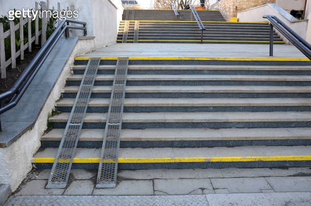 ramp combined with a gray concrete staircase and railings specially ...