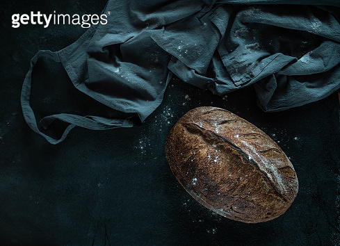 round whole grain homemade bread on a black dining table. fresh crispy ...