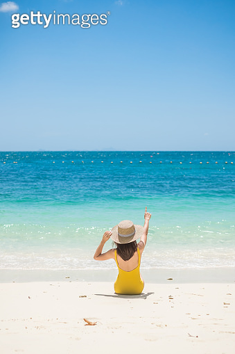 Woman tourist in yellow swimsuit and hat, happy traveler sunbathing at ...