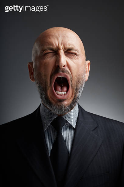 Man in a suit reacts intensely to something, having a burnout at work ...