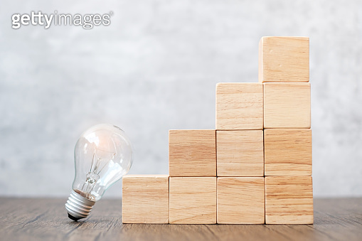 Lightbulb and wood block stack of building with business idea, creative, thinking goal, strategy ...