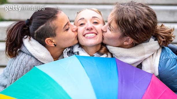 three young women in the homosexual community kiss each other, symbolic ...