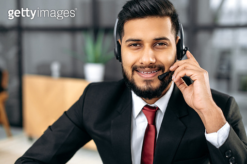 Portrait of friendly positive smart indian or arabian man with headset ...