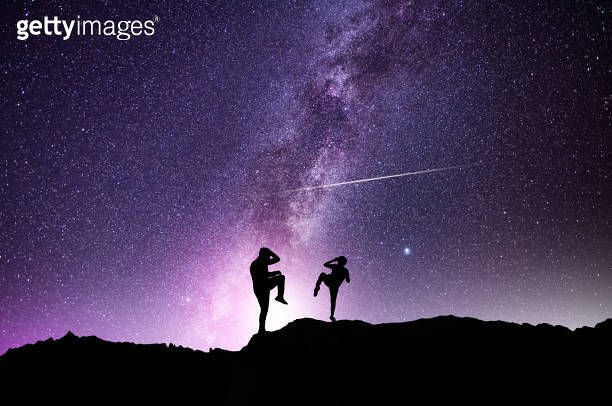 Silhouettes of karate fighters on the background of the starry sky ...
