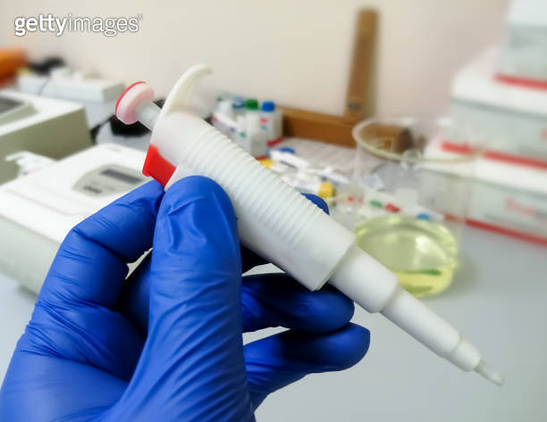 Hand holding micro pipette in laboratory. six ml micro pipette for pcr ...