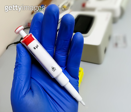 Hand holding micro pipette in laboratory. six ml micro pipette for pcr ...