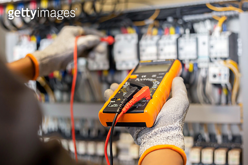 Electrician engineer uses a multimeter to test the electrical ...