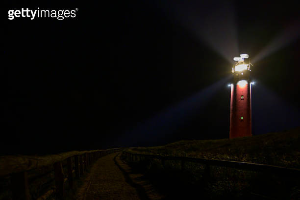 Texel lighthouse in the dunes during a stormy autumn night 이미지 ...