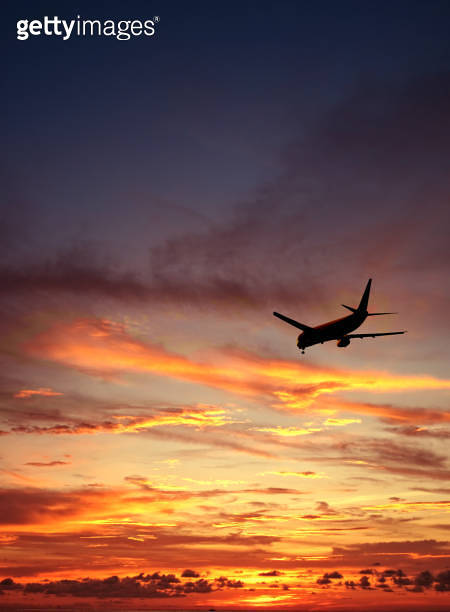 Flying commercial airplane over orange color dramatic sunset sky 이미지 ...