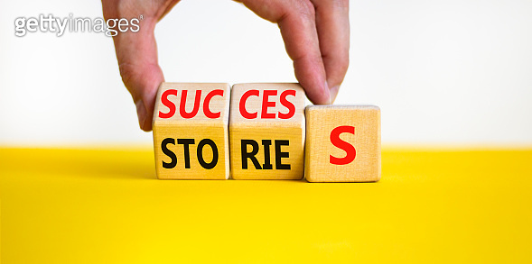 Success stories symbol. Businessman turns wooden cubes and changes the ...