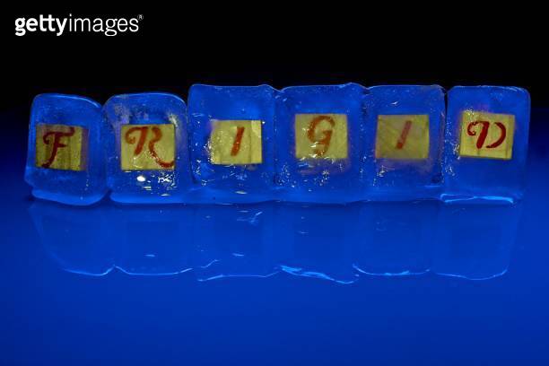 The word frigid spelled out in ice cubes illuminated using a light ...