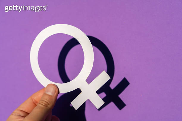 A woman holding the female symbol on a purple background, march for ...